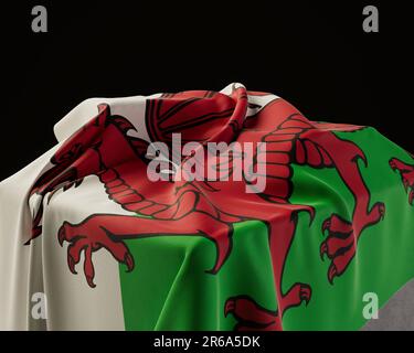 A wales flag draped over a stone plinth on an isolated dark studio ...