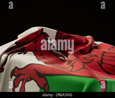 A wales flag draped over a stone plinth on an isolated dark studio ...