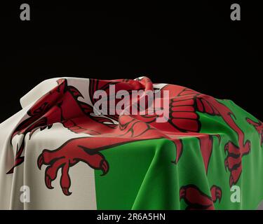 A wales flag draped over a stone plinth on an isolated dark studio ...