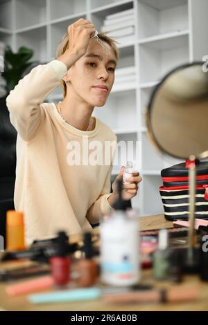 beauty blogger applying face serum near laptop and circle light Stock ...