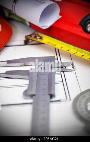 Construction drawings, caliper, tape line, calculator and helmet. Desk ...