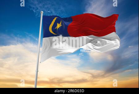 official flag of Malacca Malaysia at cloudy sky background on sunset, panoramic view. Malaysian ...