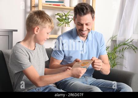 Happy man receiving greeting card from his daughter at home Stock Photo ...