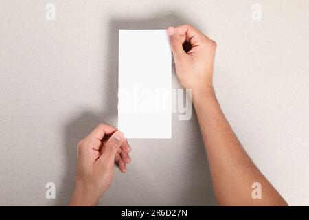 Man holding flyer on grey background, closeup. Mockup for design Stock ...