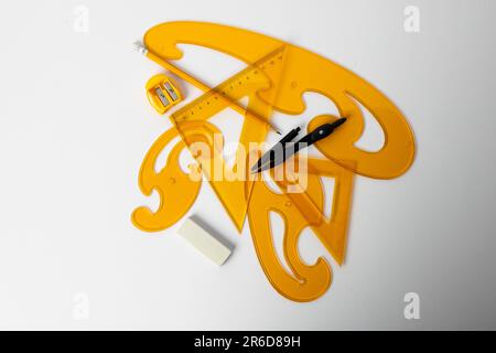 Close up of yellow rulers, compass and sharpener on white background ...