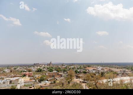 An aerial view of Orchha Fort in India in the distance, sunlit with a ...