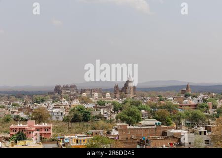 An aerial view of Orchha Fort in India in the distance, sunlit with a ...
