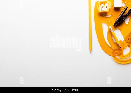 Close up of yellow rulers, compass and sharpener on white background ...