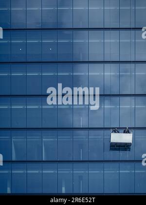 Professional high rise window cleaning service workers in gondola. Two ...