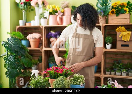 Young latin man florist cutting plants at flower shop Stock Photo - Alamy