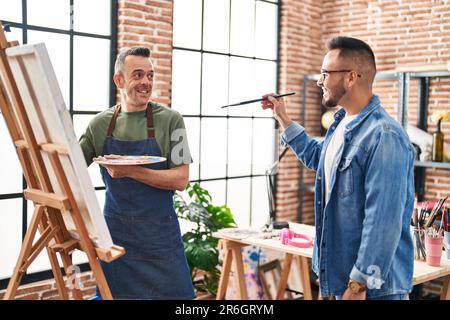 Two men artists smiling confident drawing at art studio Stock Photo - Alamy