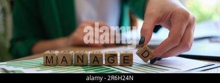 Woman collecting word managed with wooden cubes Stock Photo - Alamy