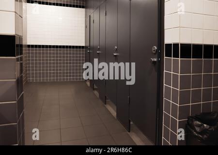 Public toilet interior with stalls and tiled walls Stock Photo - Alamy