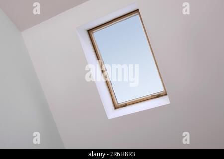 Skylight roof window and lamps on slanted ceiling in attic room Stock ...