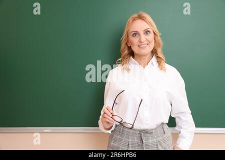 Happy professor with glasses near green board, space for text Stock ...