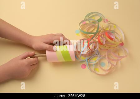 Woman holding party popper with serpentine and confetti on green ...