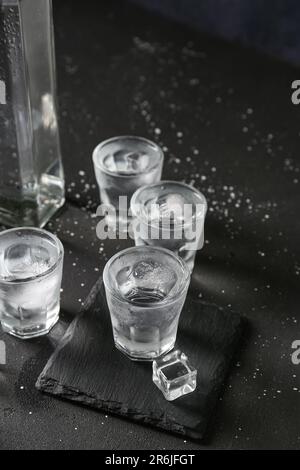 Shots of vodka with ice cubes on black background Stock Photo - Alamy