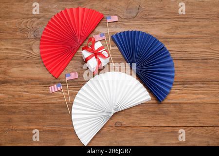 Gift box with USA flags and fans on brown wooden background. American ...