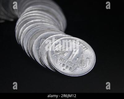 1 (one) rupee coins of india made of silver stacked together in a ...