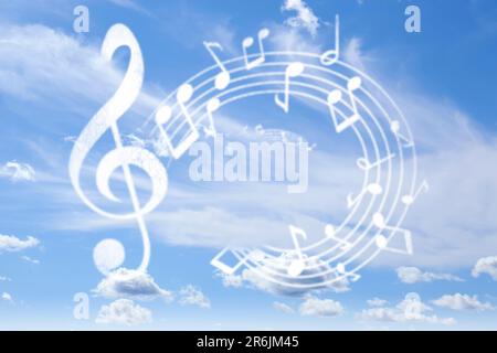 Treble clef and swirly staff with musical notes against sunset sky ...