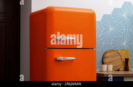 Modern closed refrigerator near colorful wall in kitchen. Domestic ...