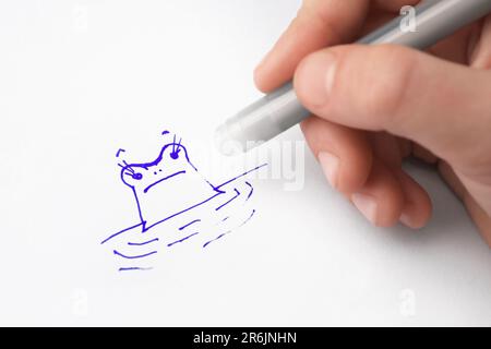 Child erasing drawing with erasable pen on paper sheet against beige ...