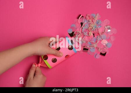 Woman holding party popper with serpentine and confetti on green ...