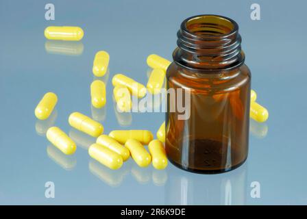 Yellow pharmaceutical capsules in brown glass Stock Photo - Alamy