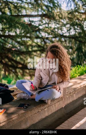High school girl is underlining important parts in the book with a ...