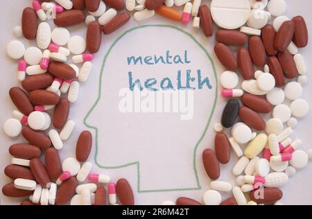 mental health concept with medicines surrounding drawing of a human ...
