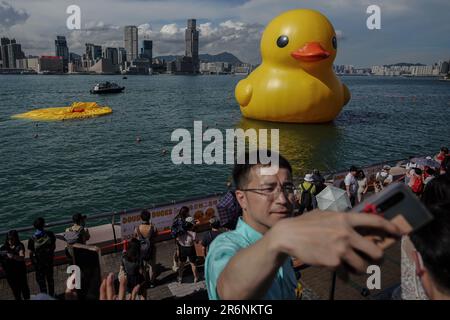A man takes selfies in front of an enormous inflatable duck which ...