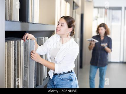 Confident female customer picking out wall tile materials for bathroom ...