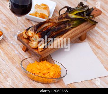 A traditional catalan dish of charred calcot onion and romesco sauce ...