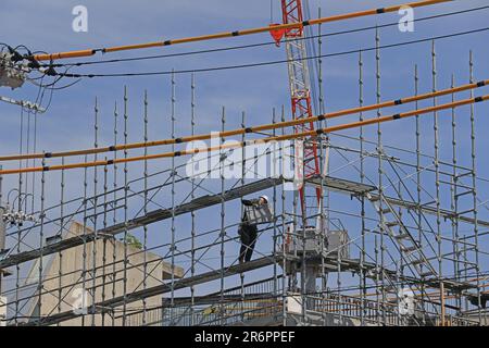 worker move on a scaffolding in the construction site of building near ...