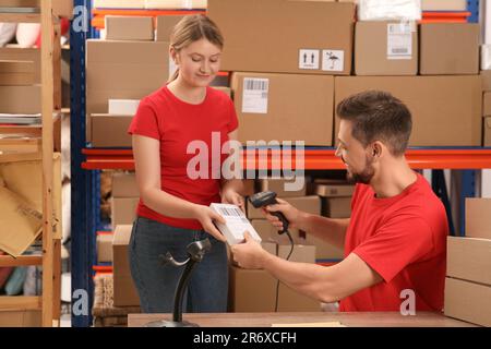 Post office workers with scanner reading parcel barcode indoors Stock ...