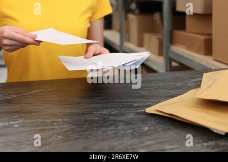Post office worker with envelopes at counter indoors, closeup Stock ...