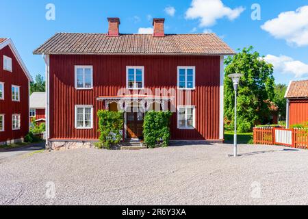 A falu-red dwelling-house with a porch and garden with out-door ...