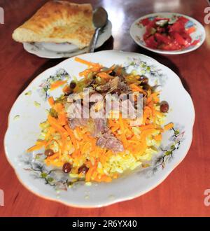 Plov is the national dish of Uzbekistan. An Uzbek man holding a plate ...