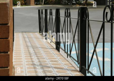 Tiled ramp with black metal railings outdoors Stock Photo - Alamy