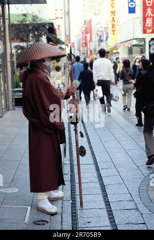 A Japanese Zen monk collecting alms on a main commercial street in ...