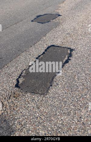 The repaired part of an asphalt road with patches, repair and ...