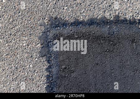 The repaired part of an asphalt road with patches, repair and ...