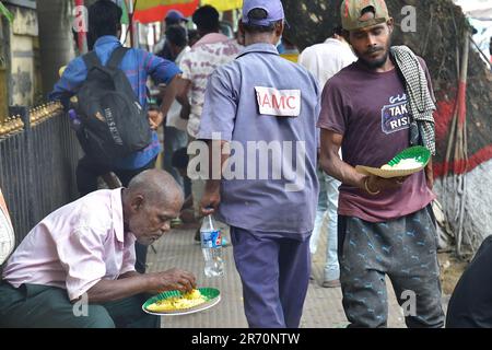 People eat food distributed by a social worker on 'World Food Safety ...
