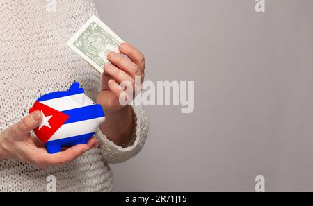 Cuban woman with money bank on the background of Cuba flag. Dotations ...