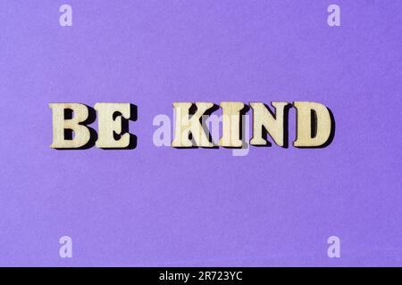 Be Kind, words in wooden alphabet letters isolated on purple background ...