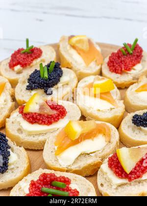 A closeup of assorted fish roe appetizers and glasses of vodka on the ...