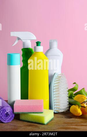 Household detergents and cleaning tools against blue tile background ...