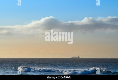 Before the typhoon came, a cargo ship sailed at sea. Dramatic sky with ...