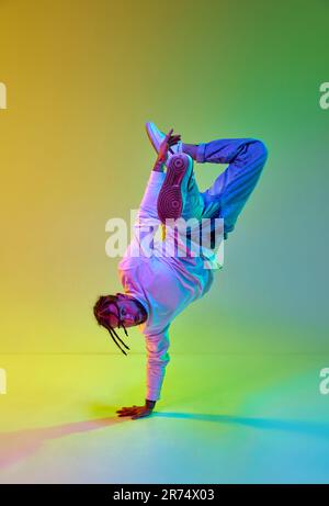 Young sportive guy with dreads hairstyle dancing hip-hop, breakdance ...