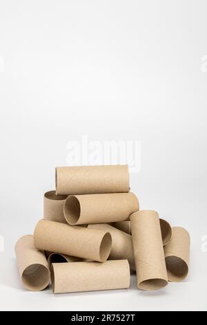 Many empty toilet paper rolls stacked as a pyramid, white background ...